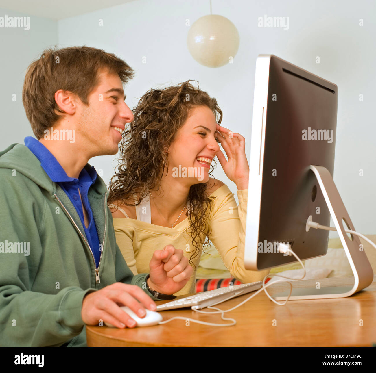 teenager couple having fun with the computer Stock Photo - Alamy