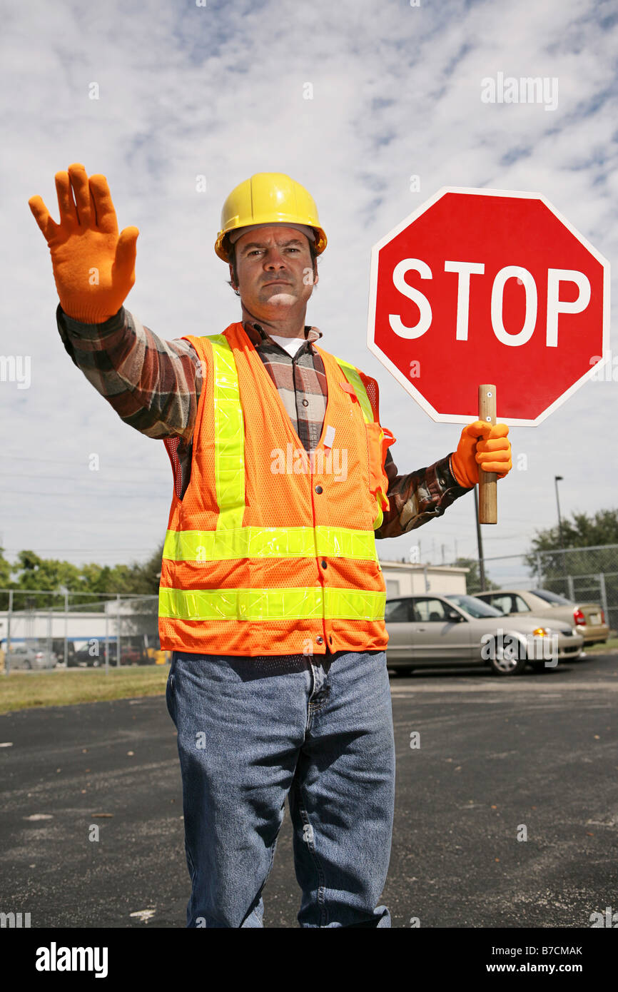A construction worker holding a stop sign and directing traffic Stock ...