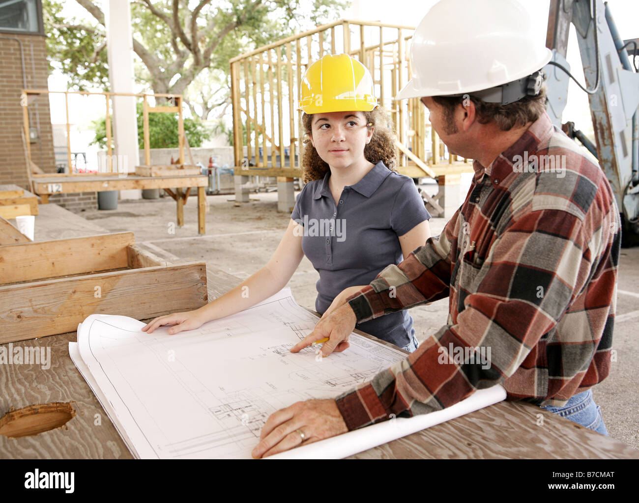 A construction apprentice listening as her foreman goes over the ...