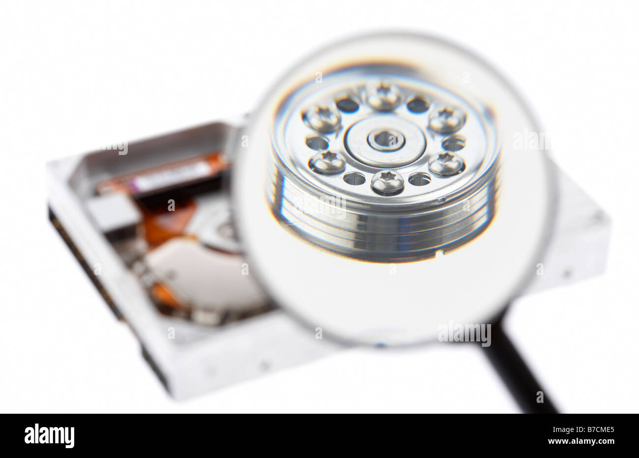 magnifying glass examining area of open computer hard drive on white ...