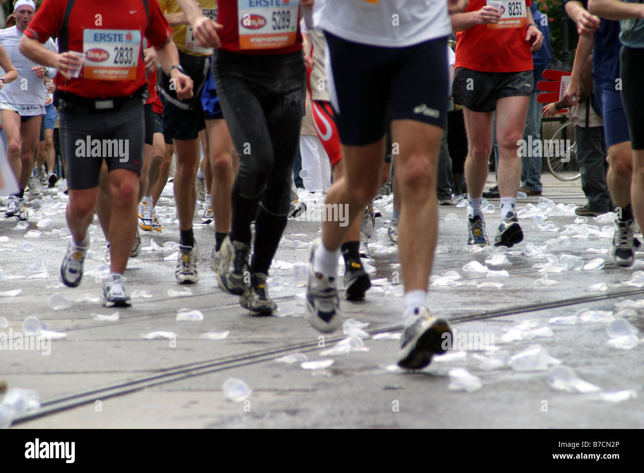 marathon runners between empty drinking cups Stock Photo - Alamy