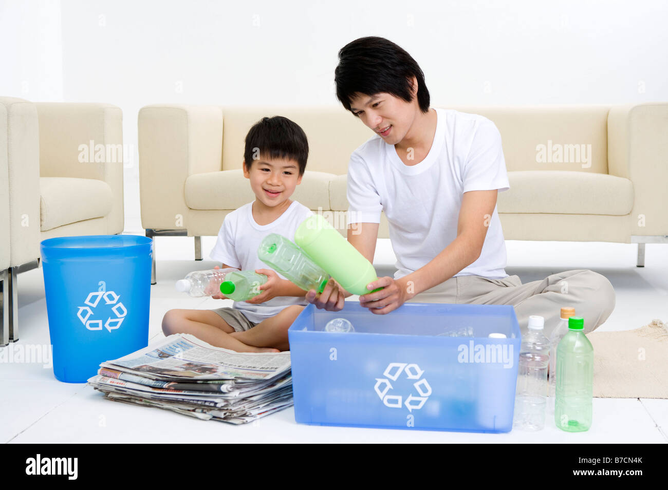 Young father and little boy recycling bottles and newspaper Stock Photo ...