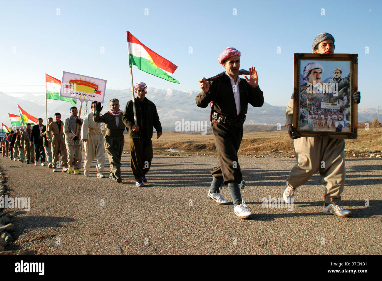 Group of Peshmerga fighters with weapons and image of the Kurdish ...