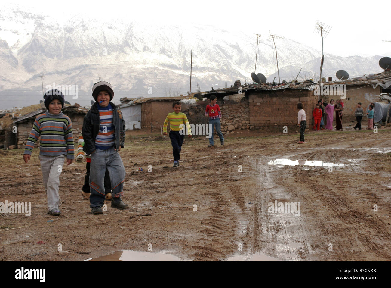 curious children in front of mud huts in a small kurdish village close ...
