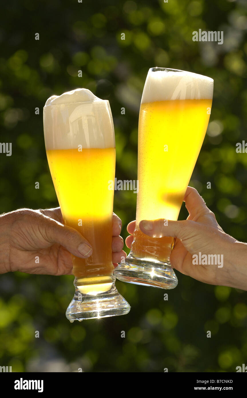 raising a toast with two wheat beer Stock Photo - Alamy