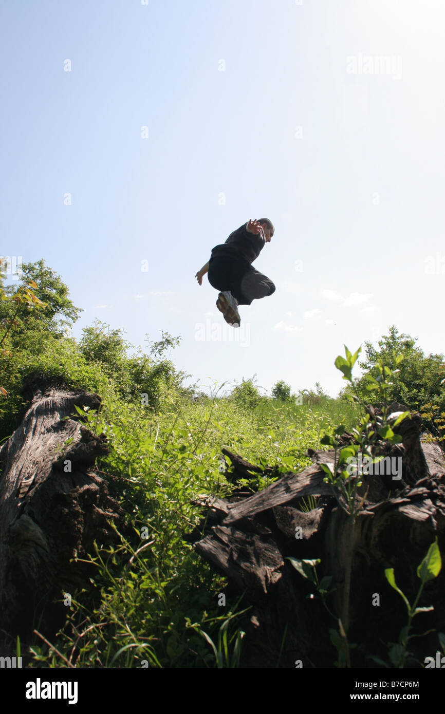 Parkour athlete at a daring jump over natural obstacles, Austria ...