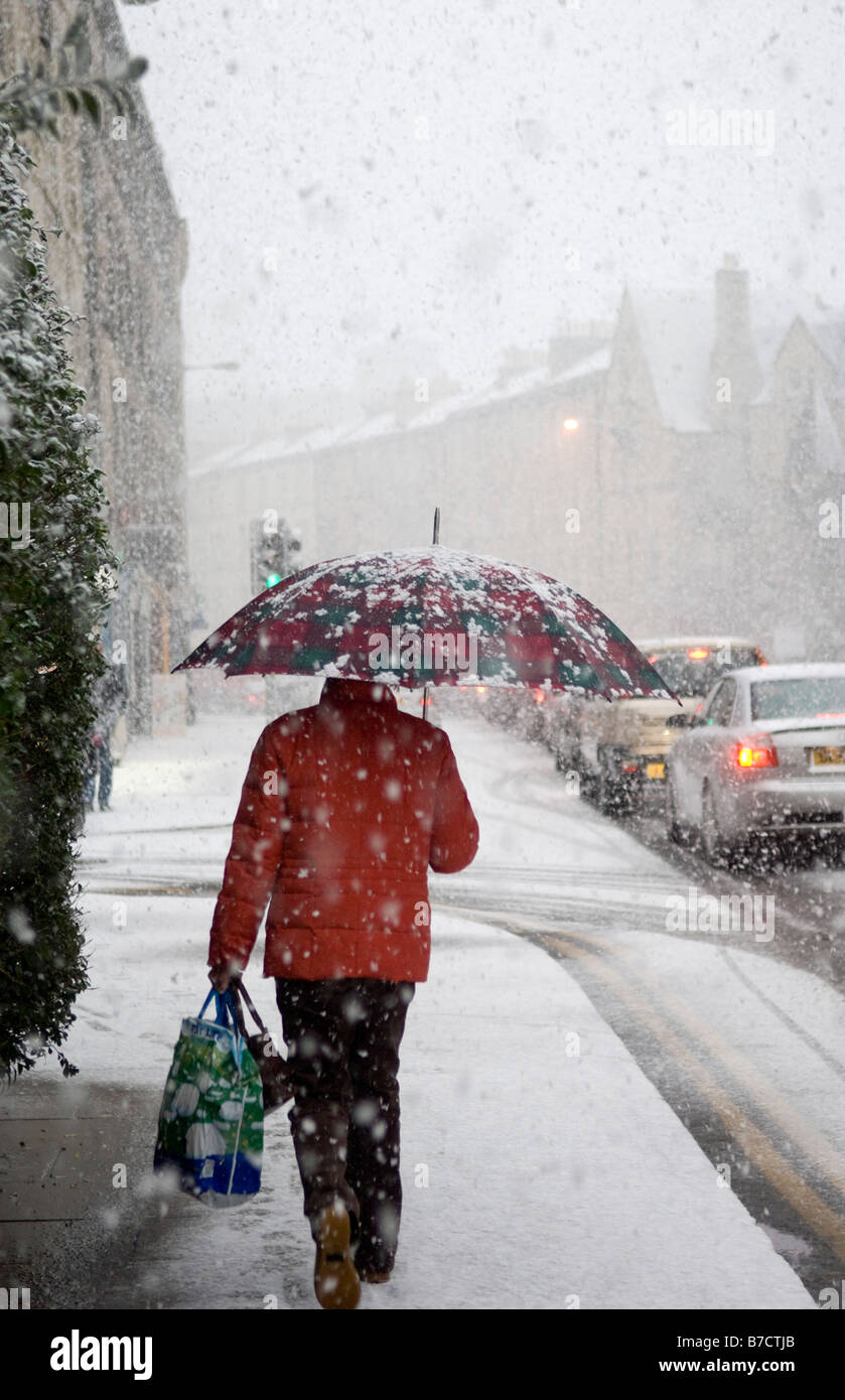 Woman walking in heavy snowfall snow on a pavement Stock Photo - Alamy