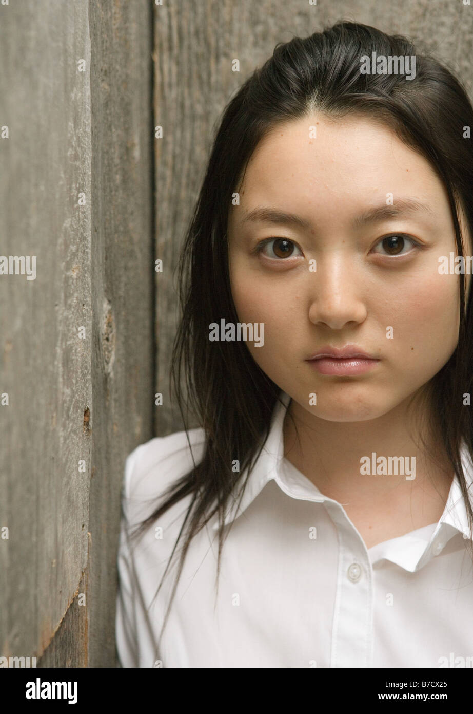 Young woman by wall Stock Photo - Alamy