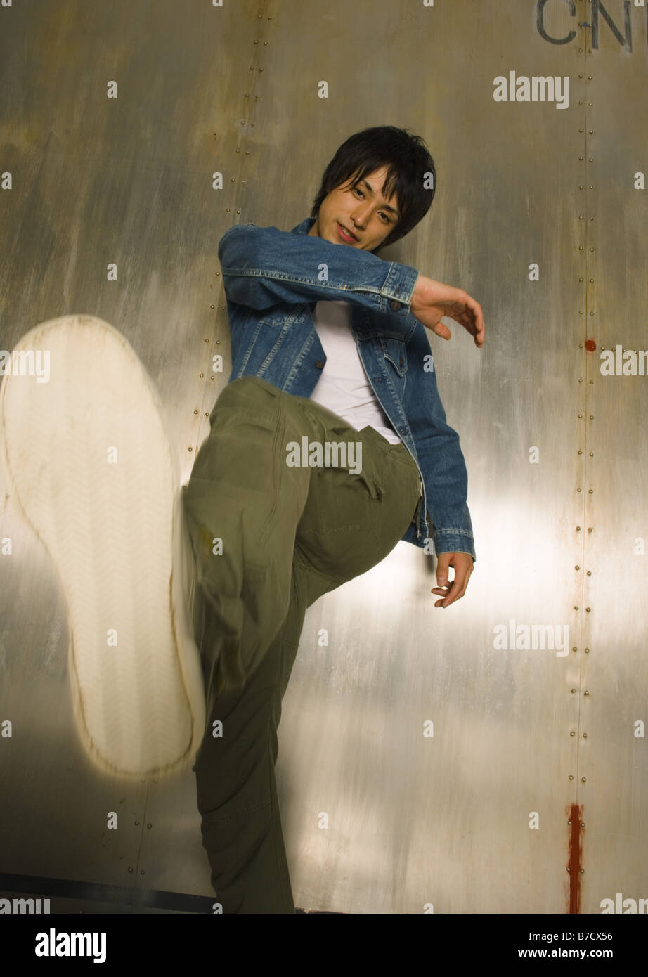 Young man kicking Stock Photo - Alamy