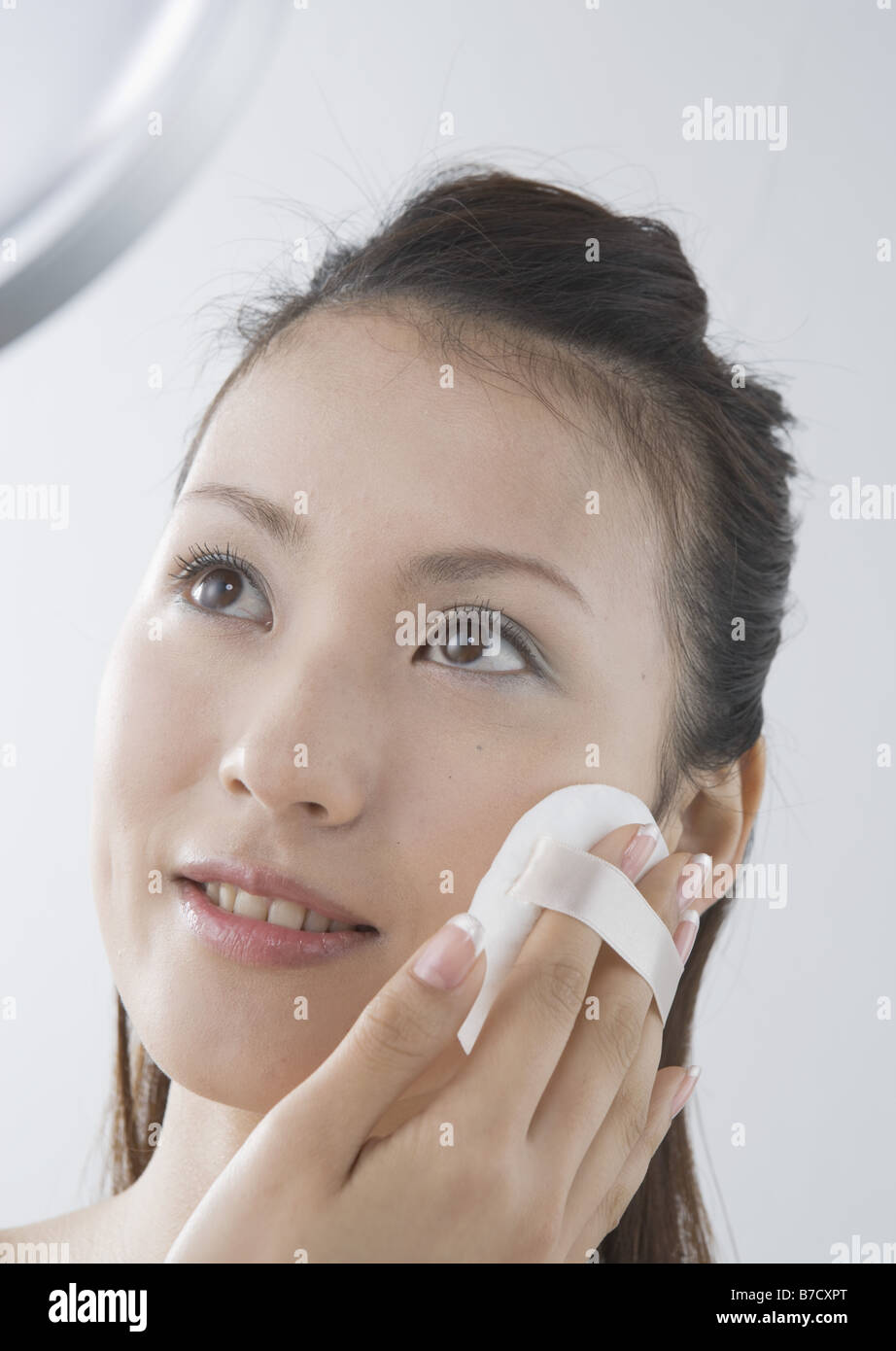 Woman applying powder with puff Stock Photo - Alamy