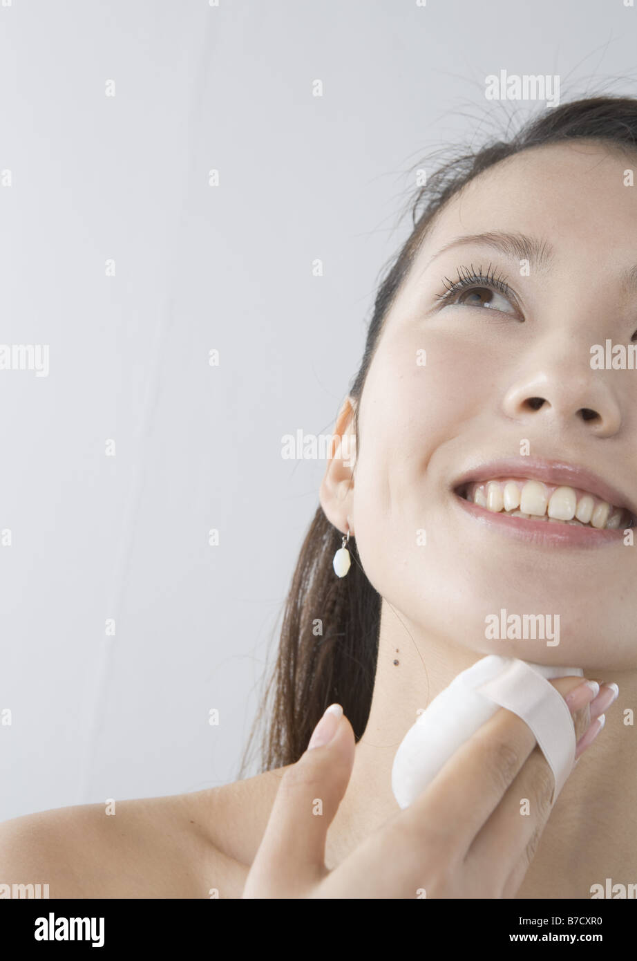 Woman applying powder with puff Stock Photo - Alamy