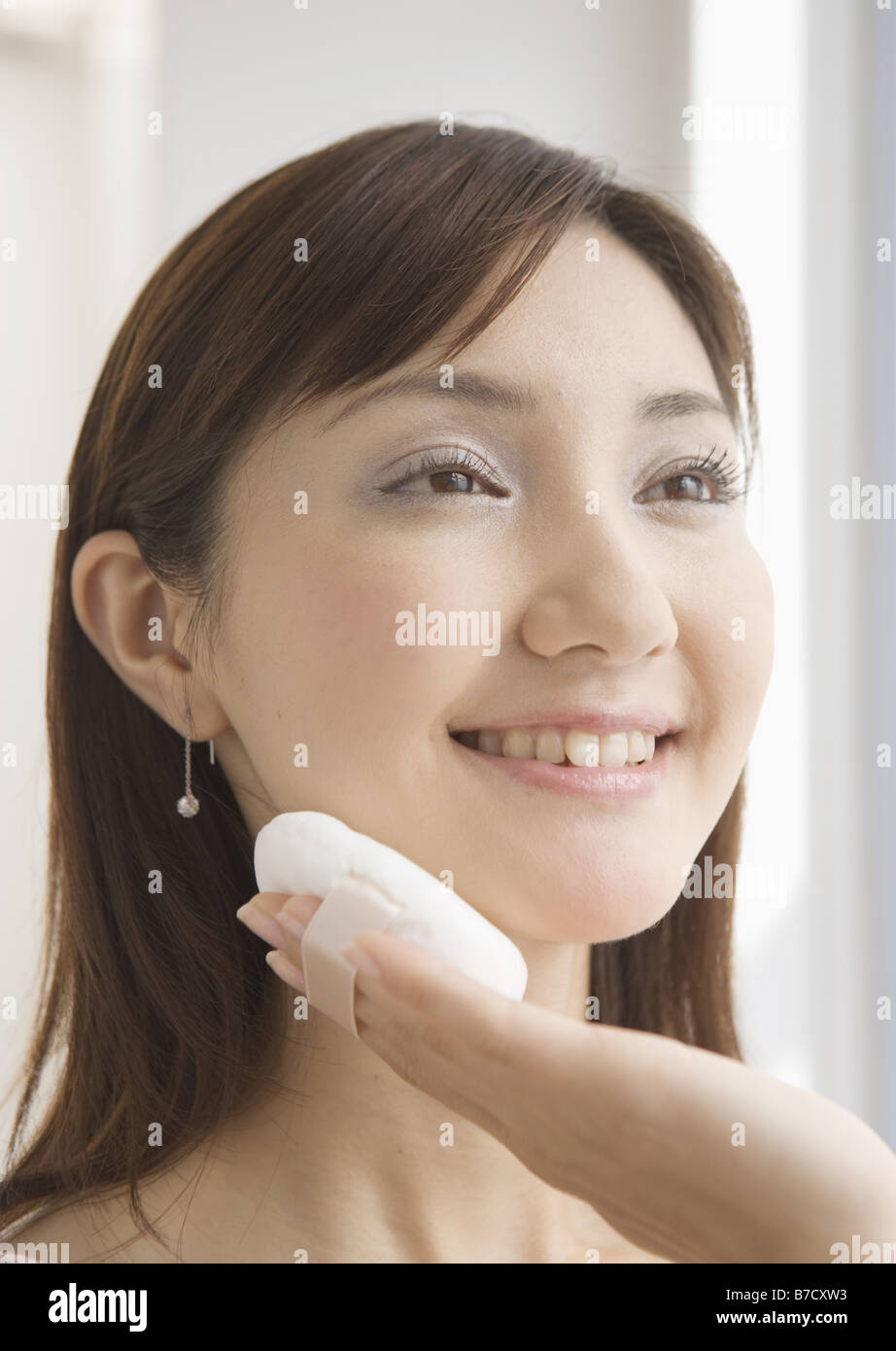 Woman applying powder with puff Stock Photo - Alamy