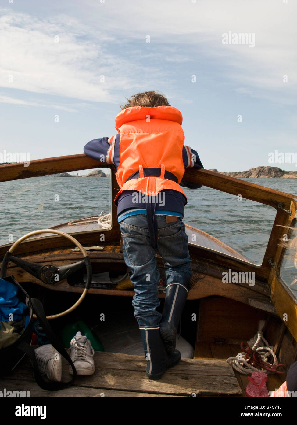 A boy riding in a motorboat, rear view Stock Photo - Alamy