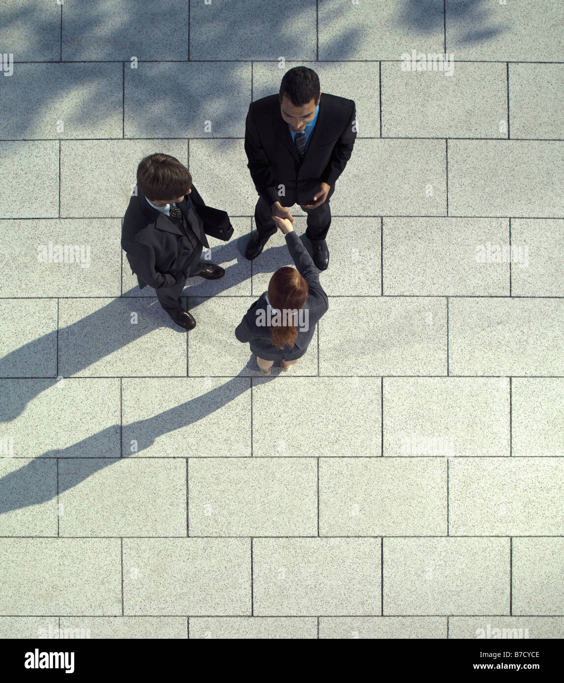 Three business people shaking hands Stock Photo - Alamy