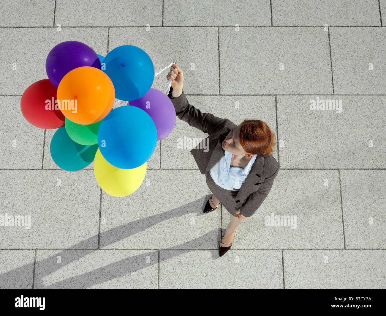 A businesswoman holding a bunch of helium balloons Stock Photo - Alamy
