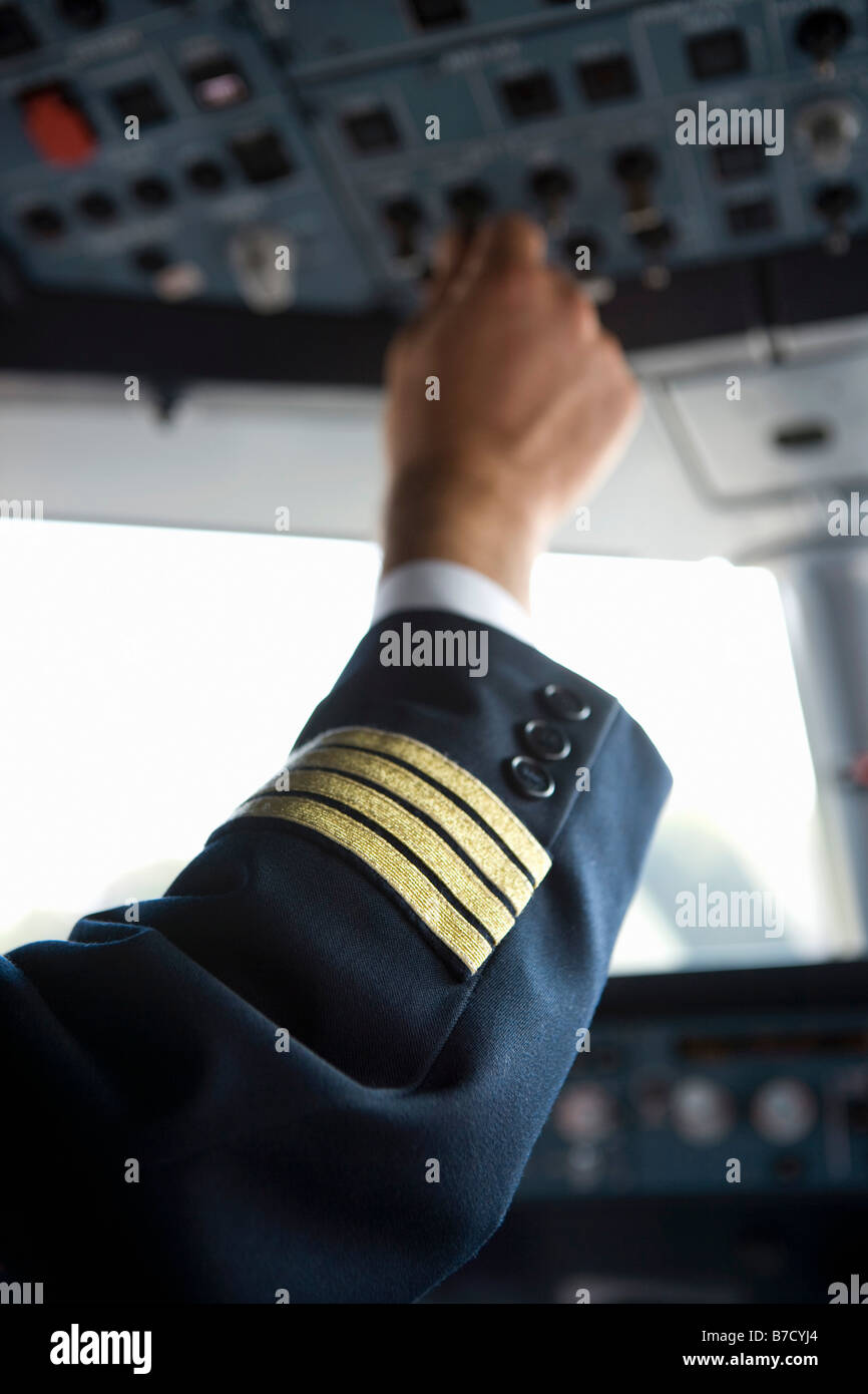 A pilot's hand using the control panel in the cockpit of a commercial ...