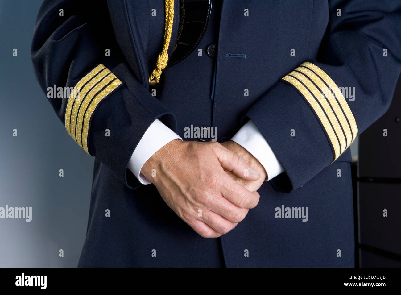 The midsection of a pilot standing with his hands clasped Stock Photo ...