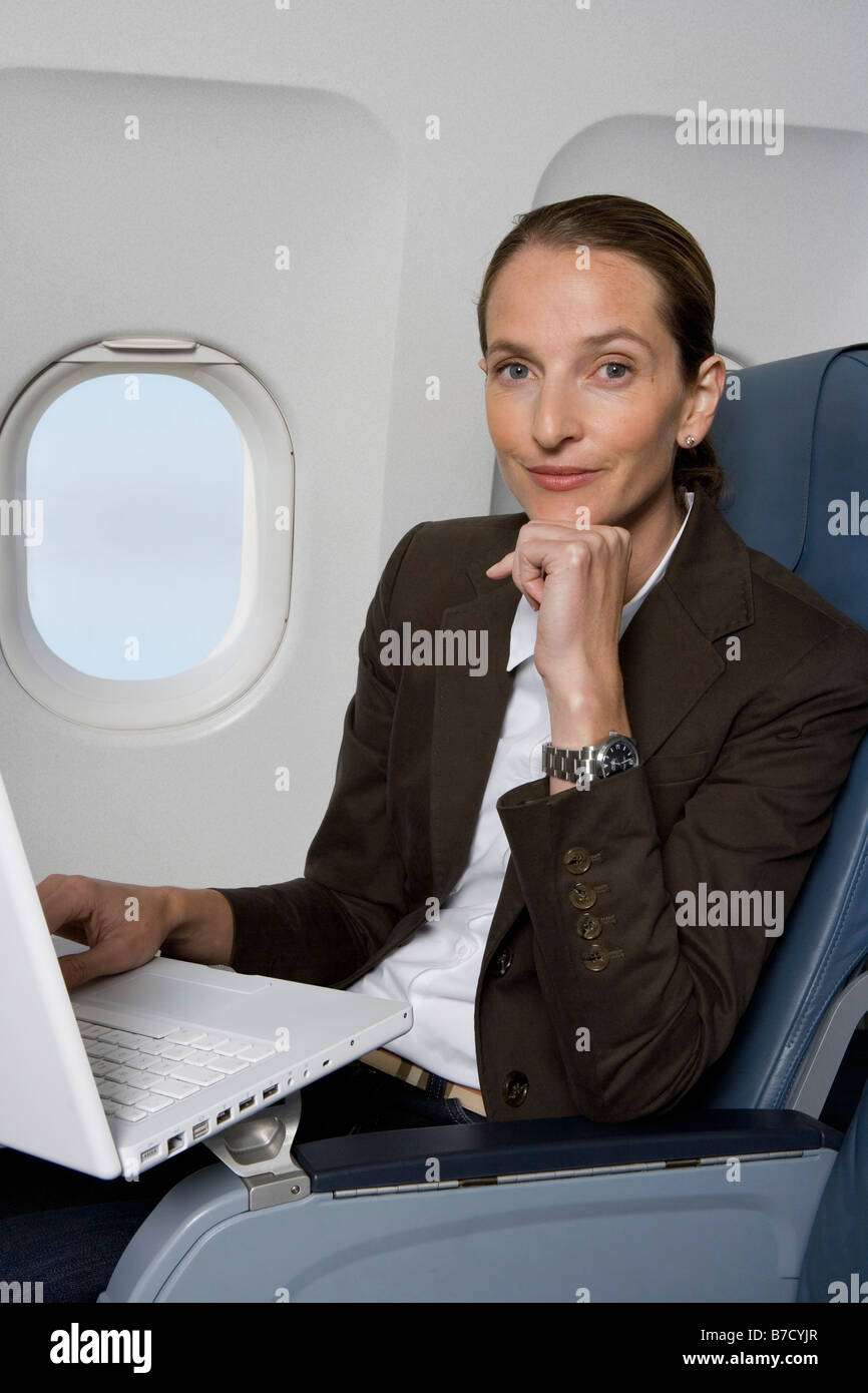 A businesswoman working on a laptop on a plane Stock Photo - Alamy