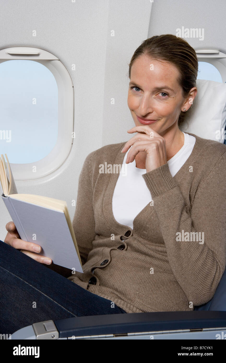 A female passenger reading on a plane Stock Photo - Alamy