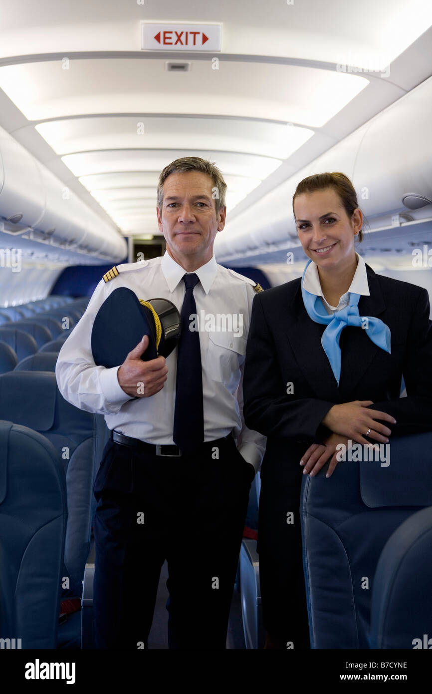 A pilot and a flight attendant standing in the cabin of a plane Stock ...