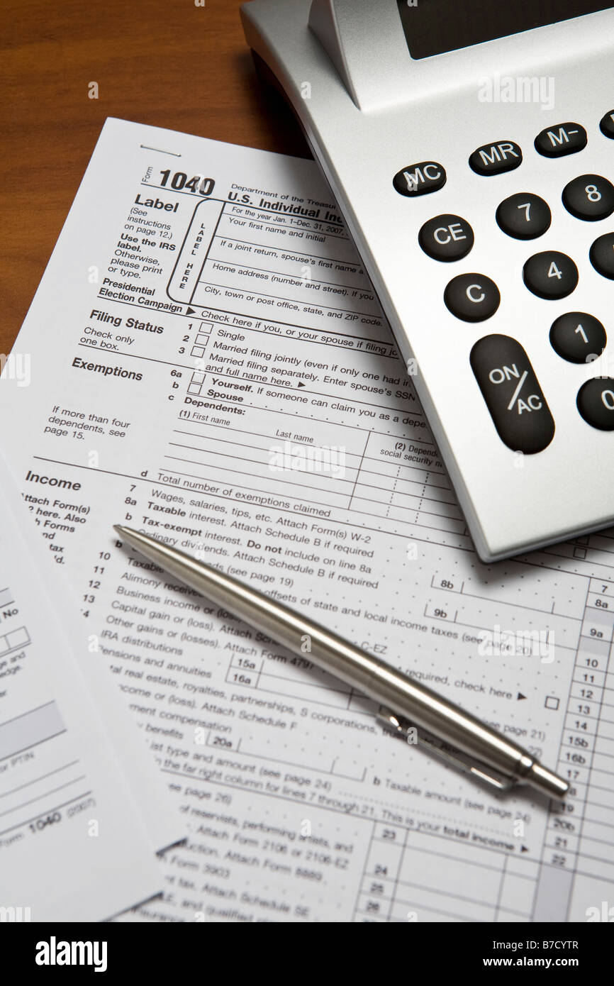 A calculator and pen on top of a tax return form Stock Photo - Alamy