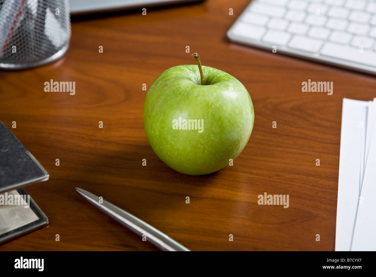 A green apple on an office desk Stock Photo - Alamy