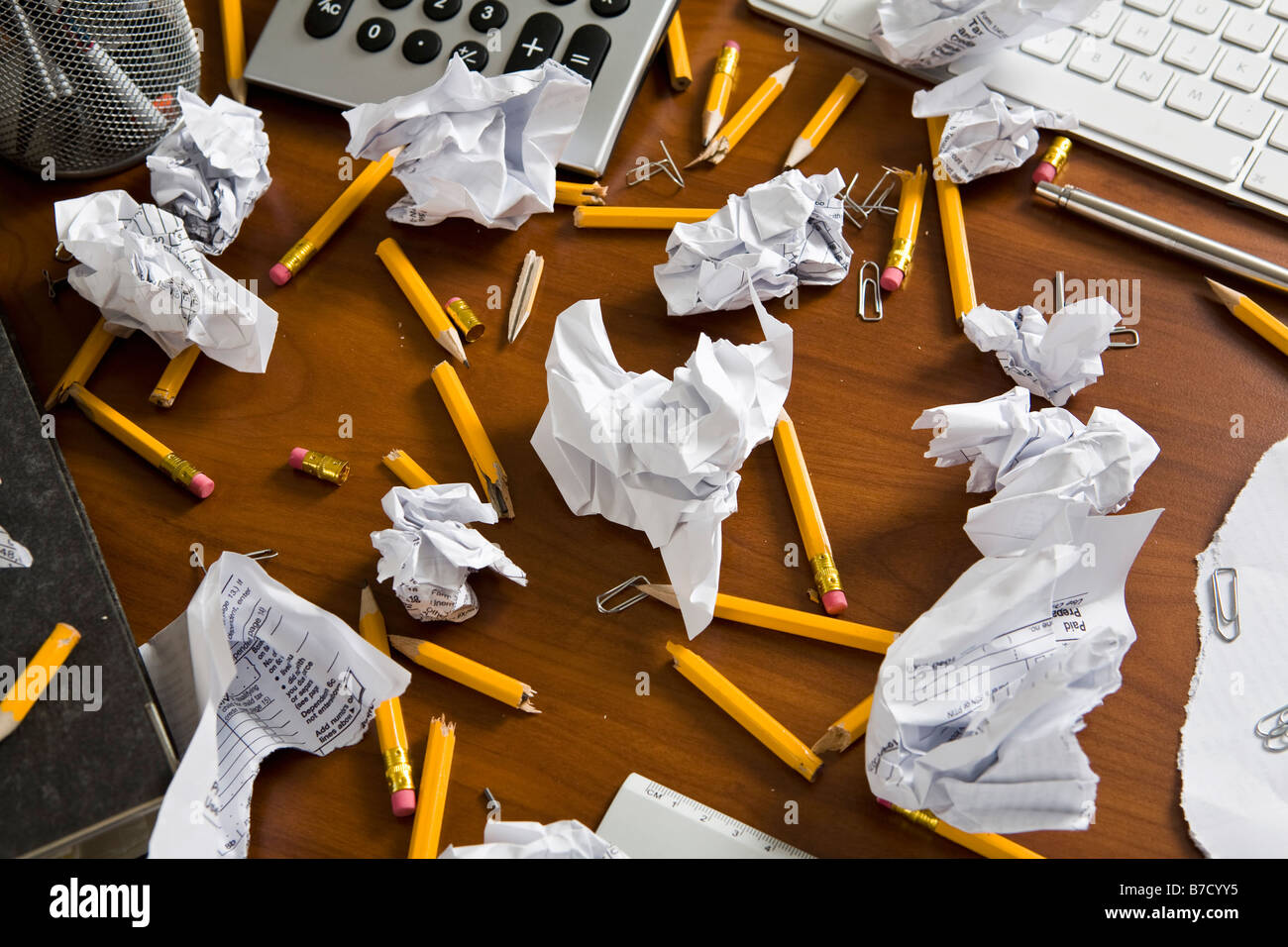An office desk cluttered with pencils and crumpled paper Stock Photo ...
