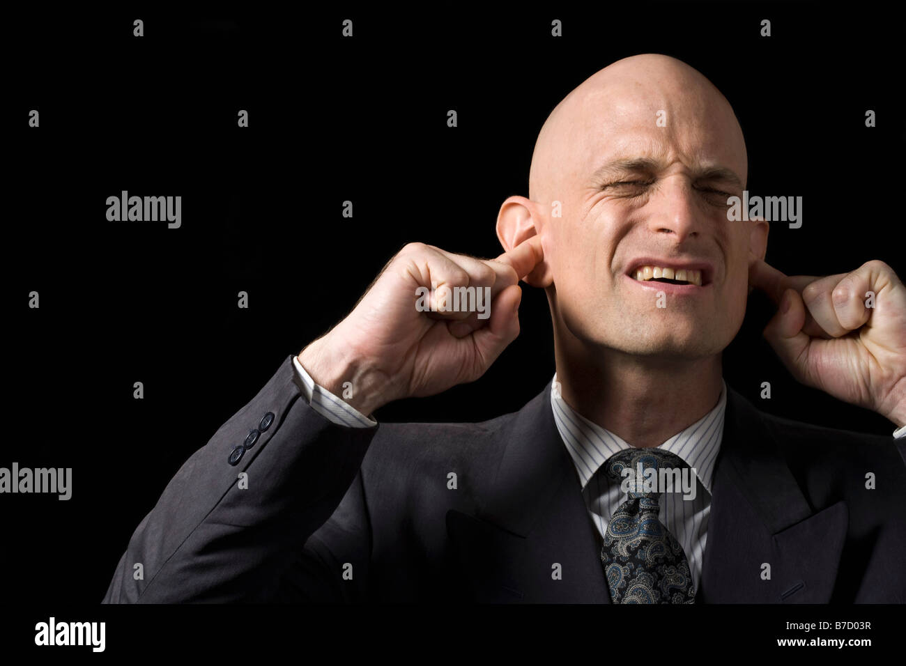 A man blocking his ears with his fingers Stock Photo - Alamy