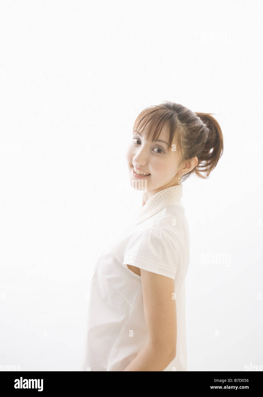 Woman looking over shoulder Stock Photo - Alamy