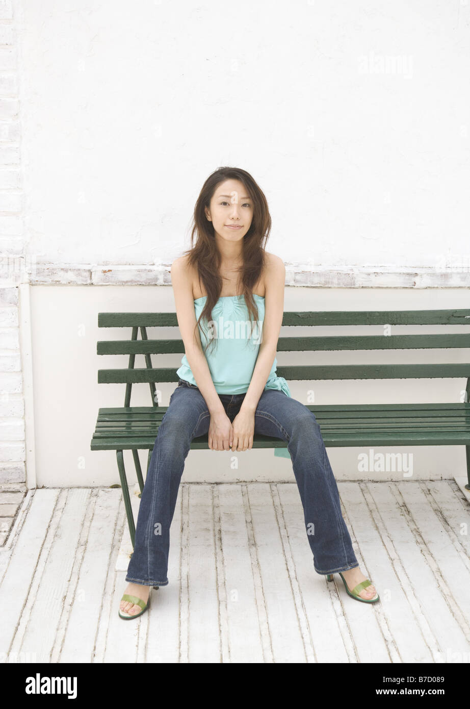 Woman sitting on bench Stock Photo - Alamy