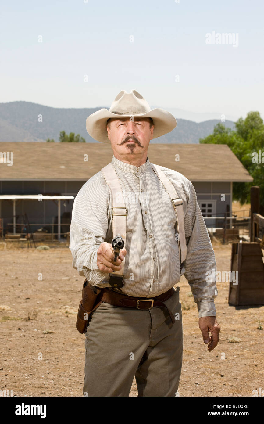 Portrait of a cowboy aiming his gun Stock Photo - Alamy