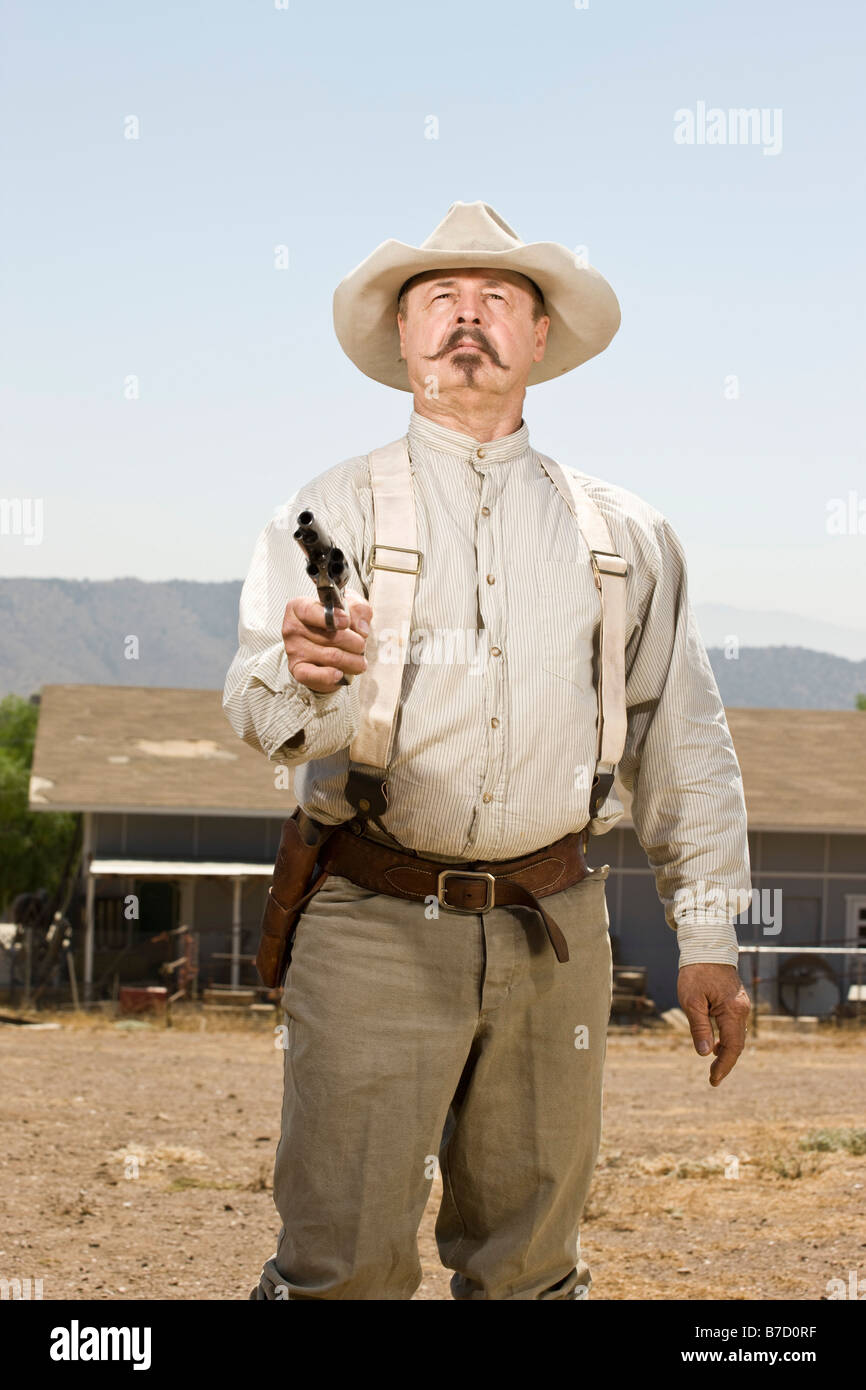 Portrait of a cowboy aiming his gun Stock Photo - Alamy