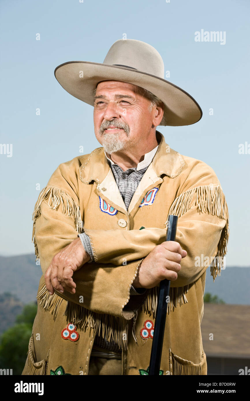 Portrait of a cowboy standing with his gun Stock Photo - Alamy
