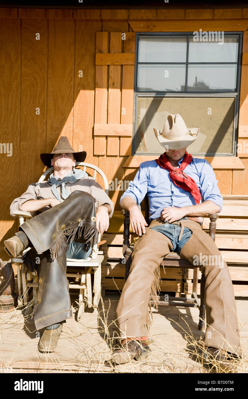 Two cowboys sleeping in chairs Stock Photo - Alamy