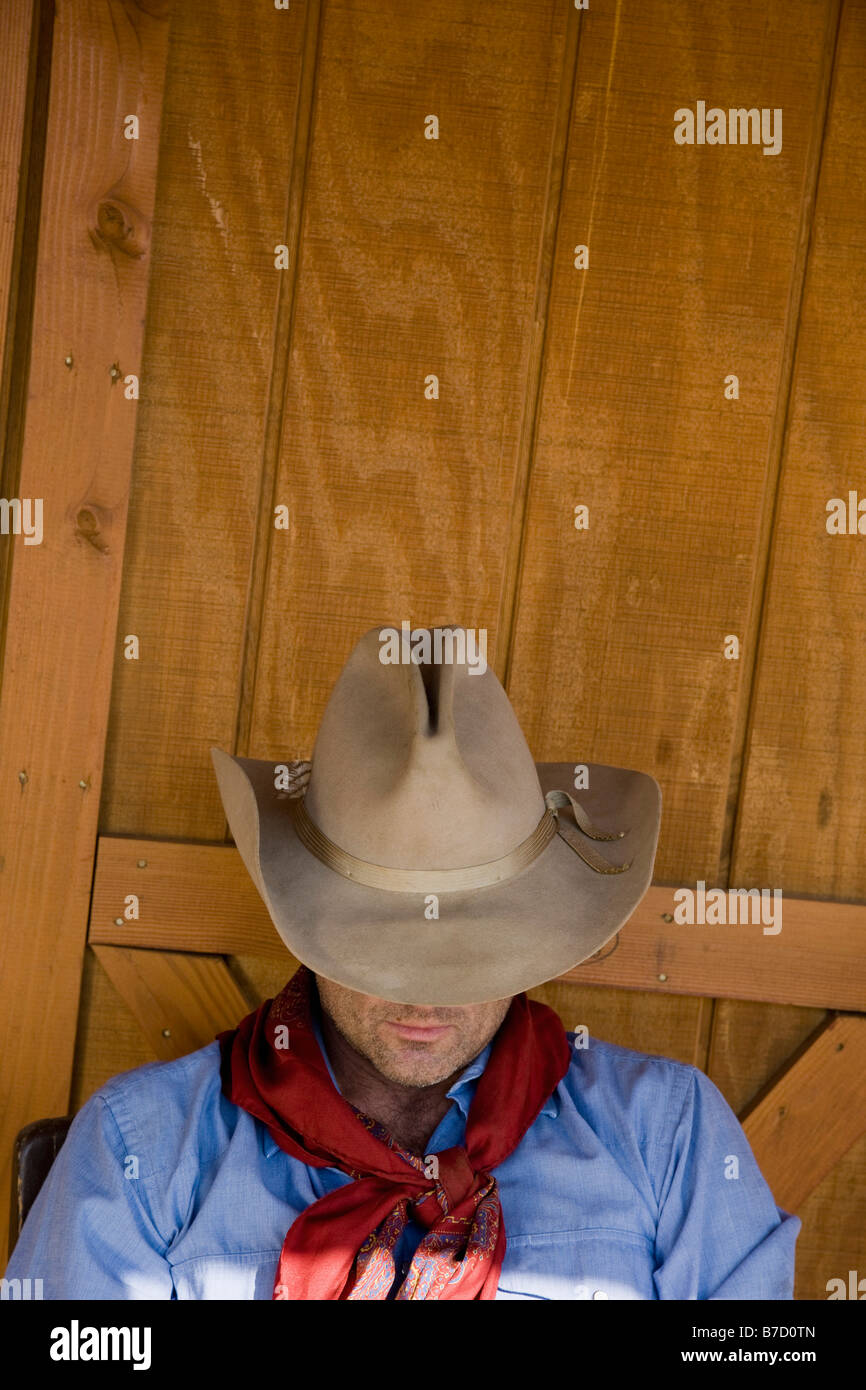 A cowboy resting with his hat tilted over his face Stock Photo - Alamy