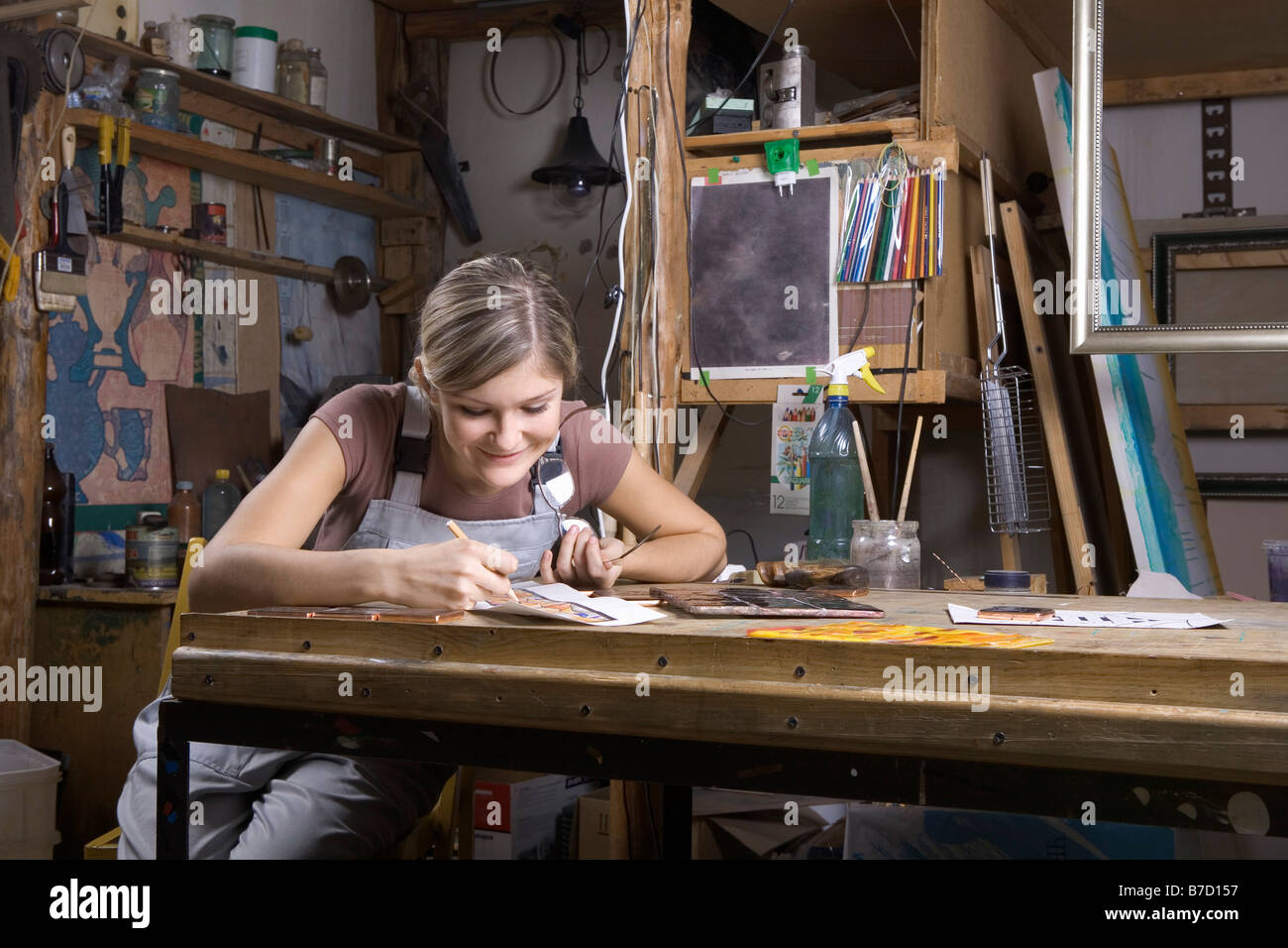A young woman working in an art studio Stock Photo - Alamy