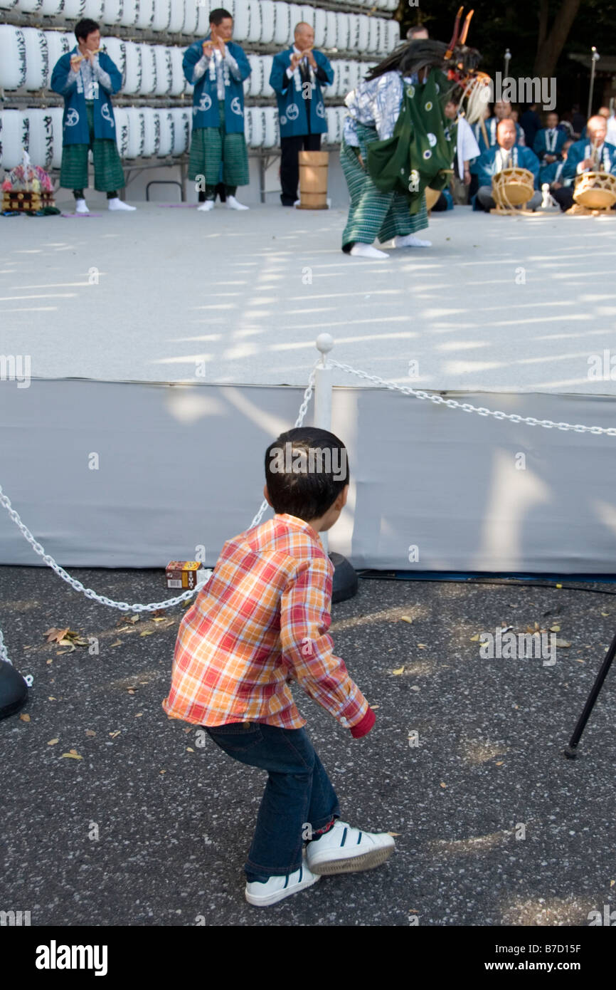 Young boy following the moves of a traditional shishima dance. Meiji ...