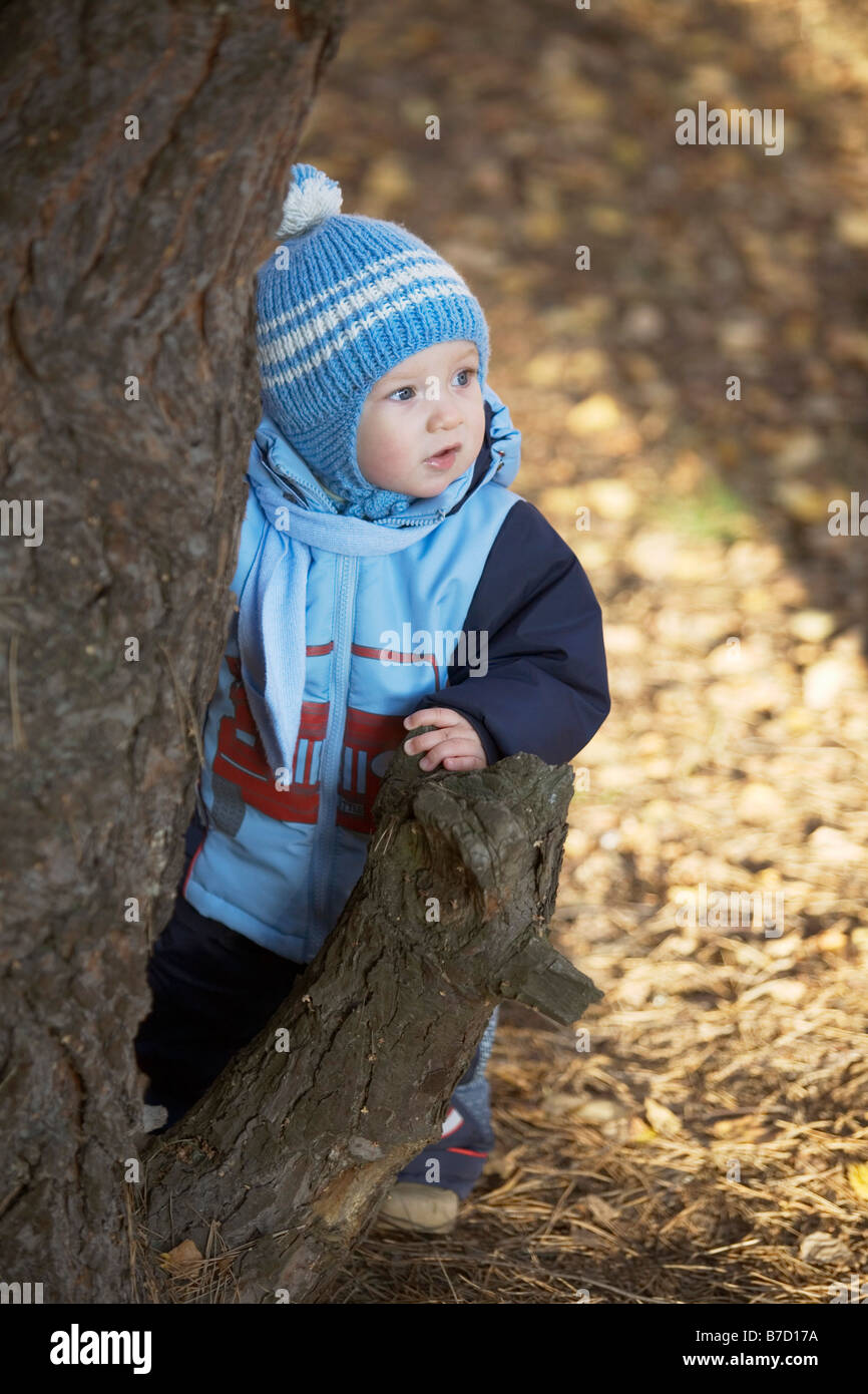 A baby boy leaning on a tree stump Stock Photo - Alamy