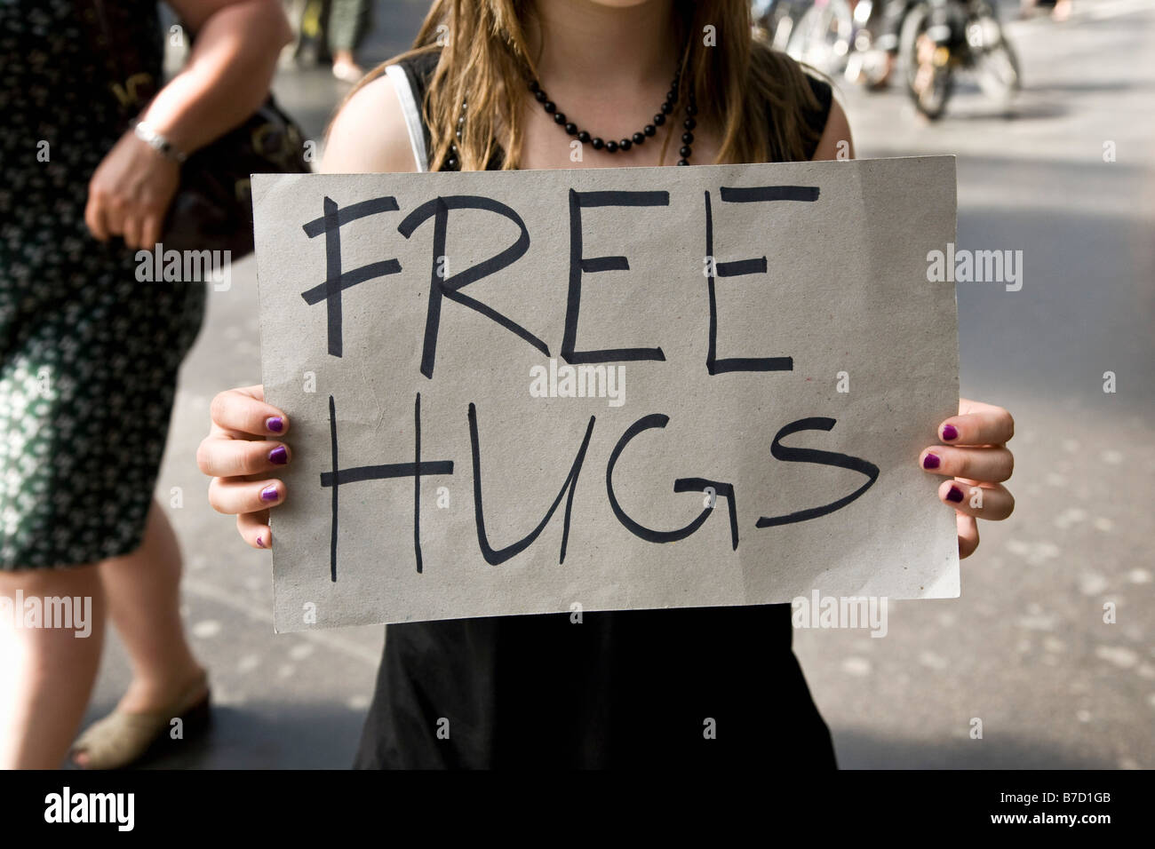 A young woman holding a sign saying Free Hugs Stock Photo - Alamy