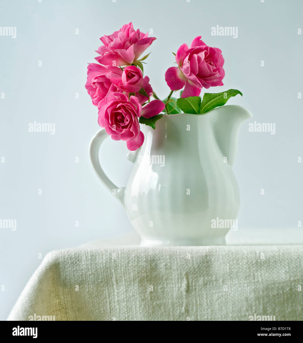 bouquet of small roses in a ceramic milk pitcher Stock Photo - Alamy