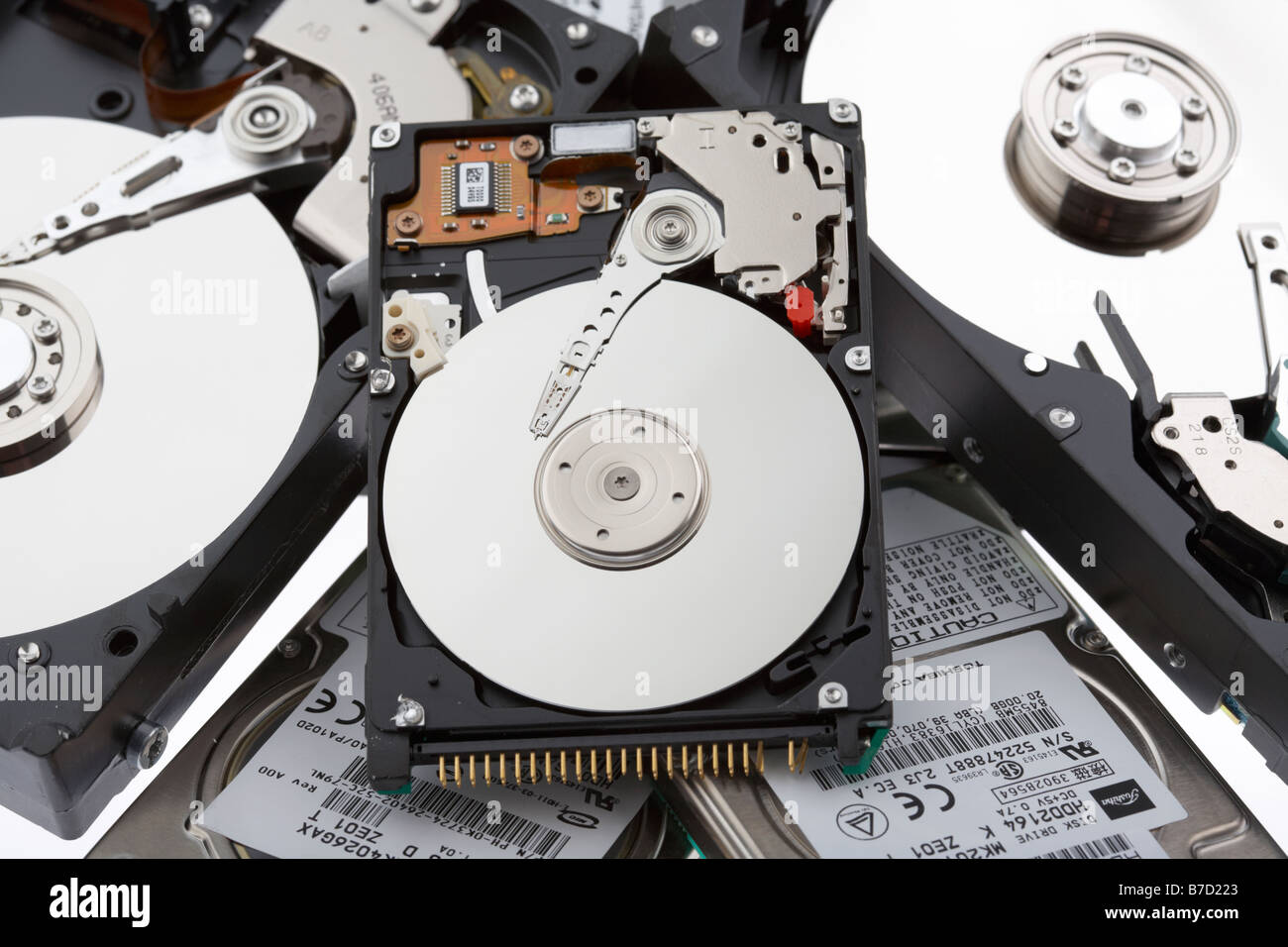 selection of open computer hard drives piled up on white background ...