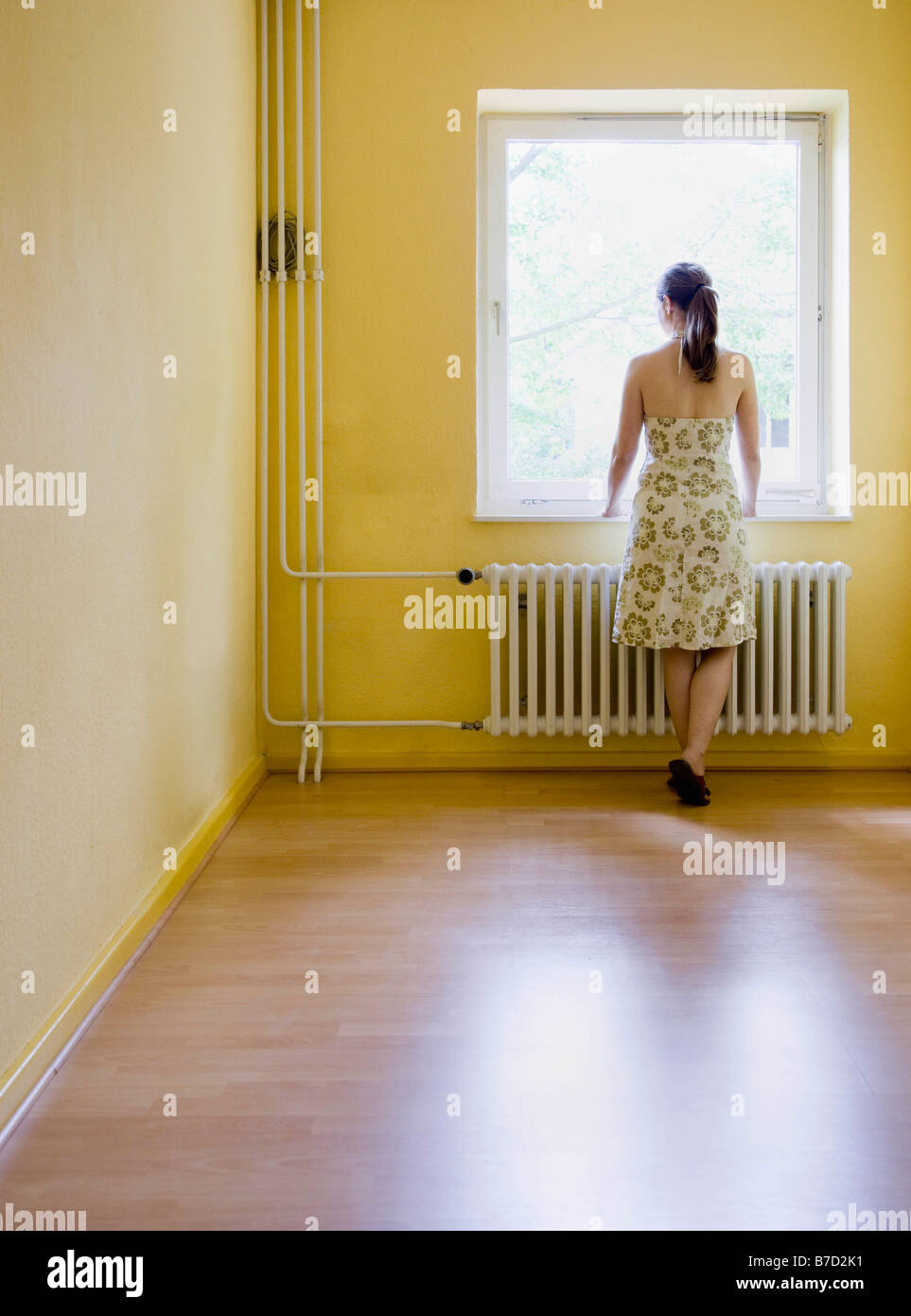 Woman looking out a window Stock Photo - Alamy