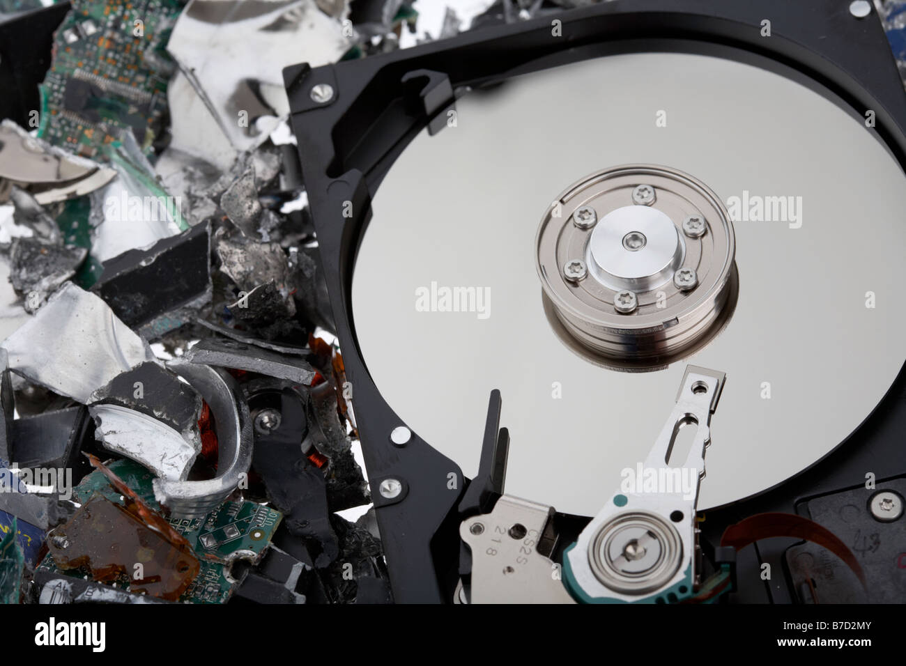 open computer hard drive sitting on a pile of shredded computer hard ...