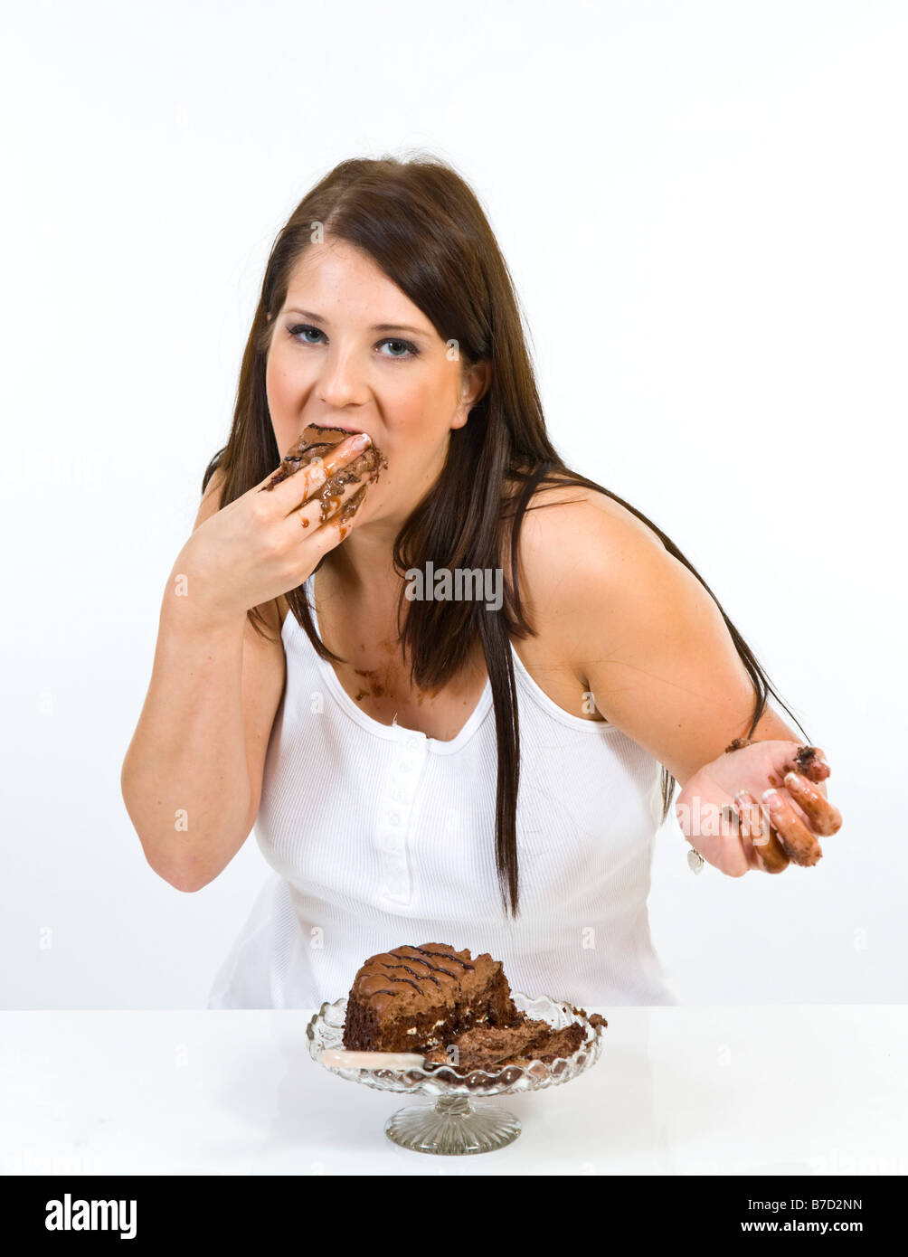 Attractive young woman messily eating a slice of chocolate gateau Stock ...