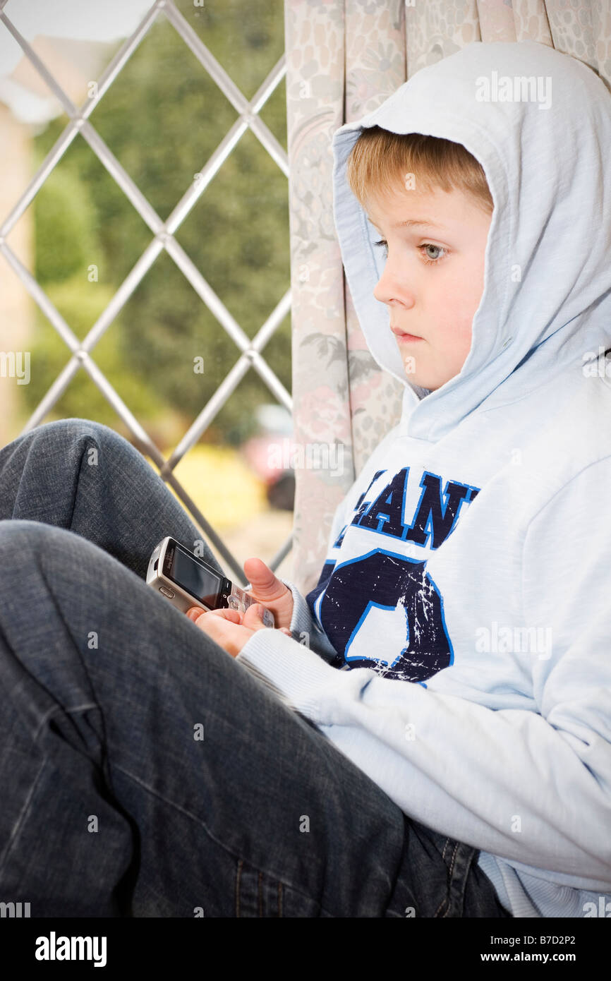 boy waits anxiously at home with mobile phone Stock Photo - Alamy