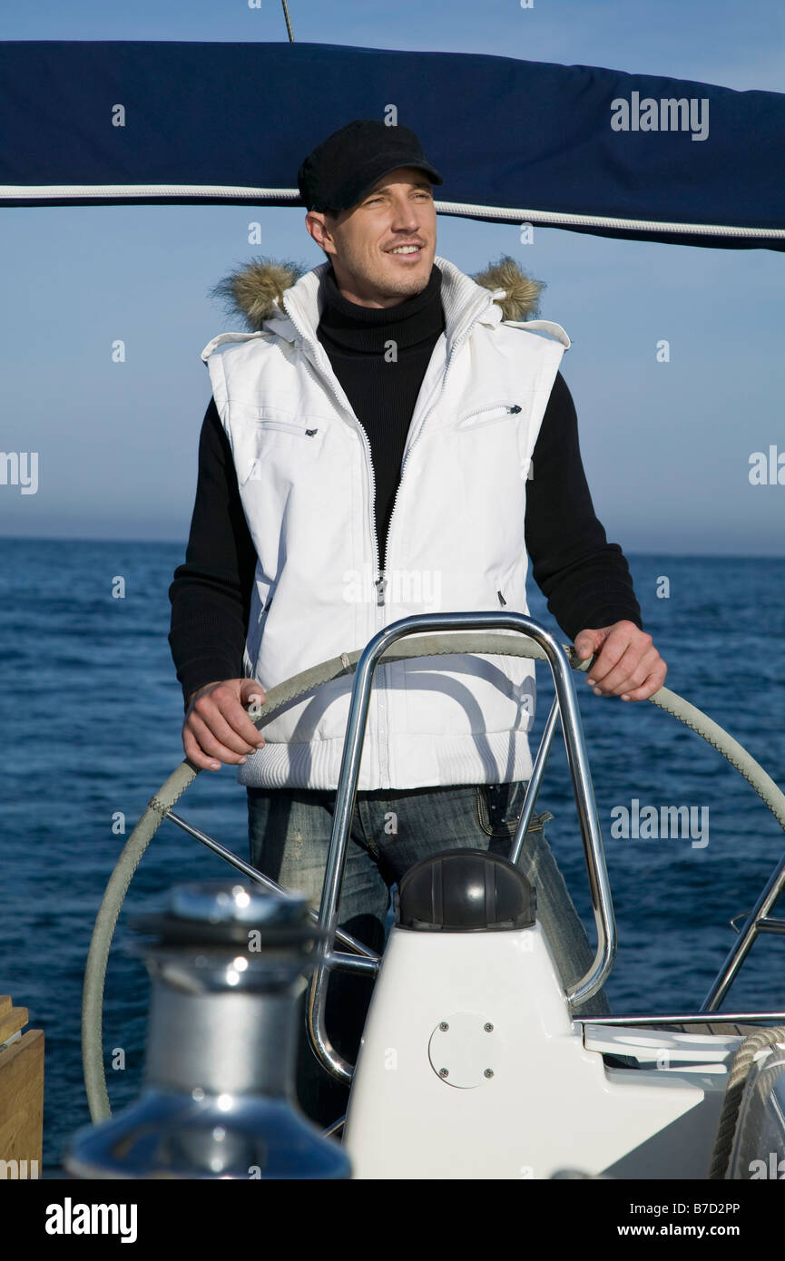 A man at the helm of a yacht Stock Photo - Alamy