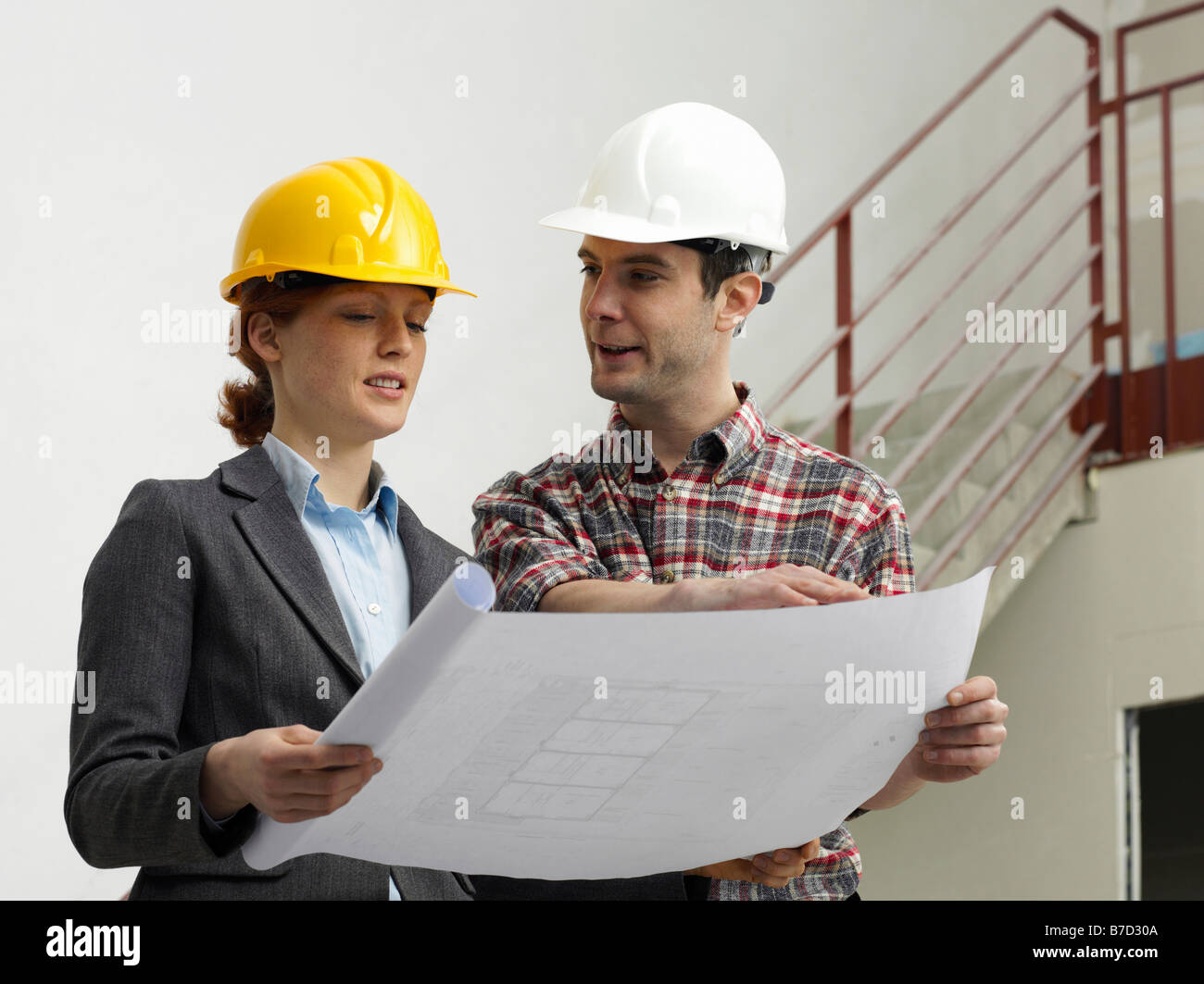 An architect speaking with a construction worker on a construction site ...