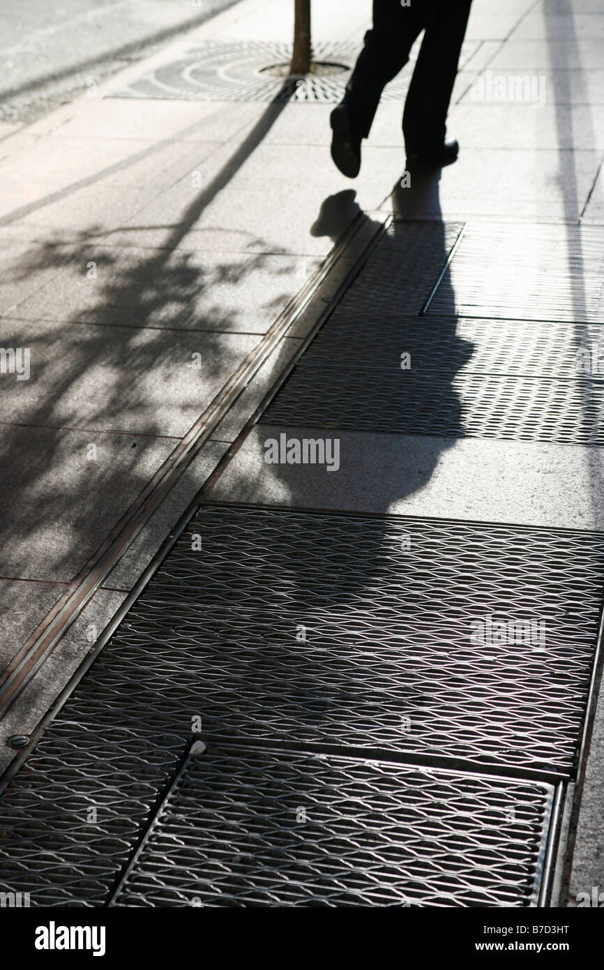 The shadow of a person walking along the street Stock Photo - Alamy