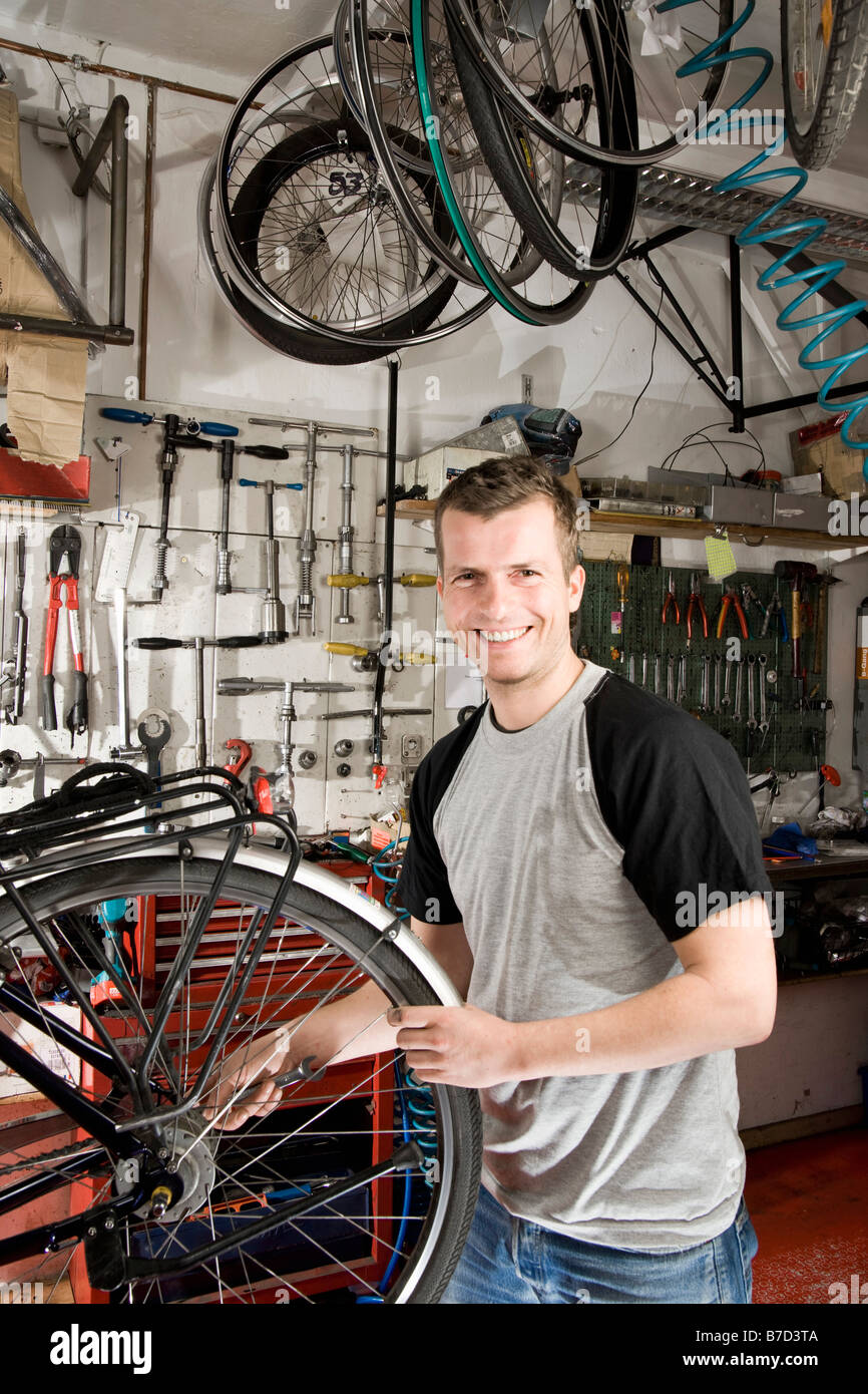 A man repairing a bike in a workshop Stock Photo - Alamy