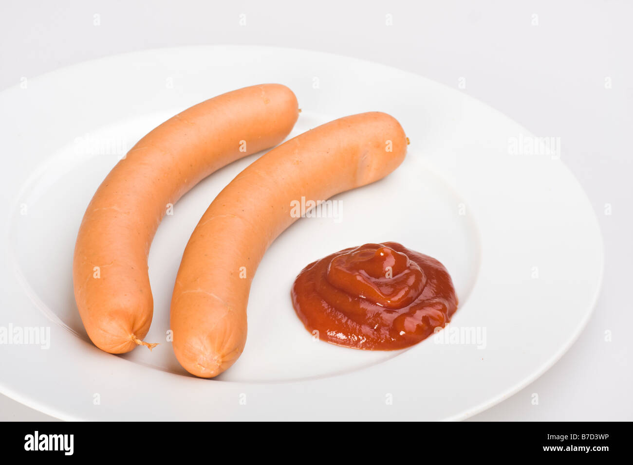 a pair of wieners on a white plate Stock Photo - Alamy
